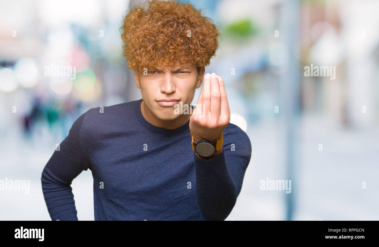 Young handsome man with afro hair Doing Italian gesture with hand and ...