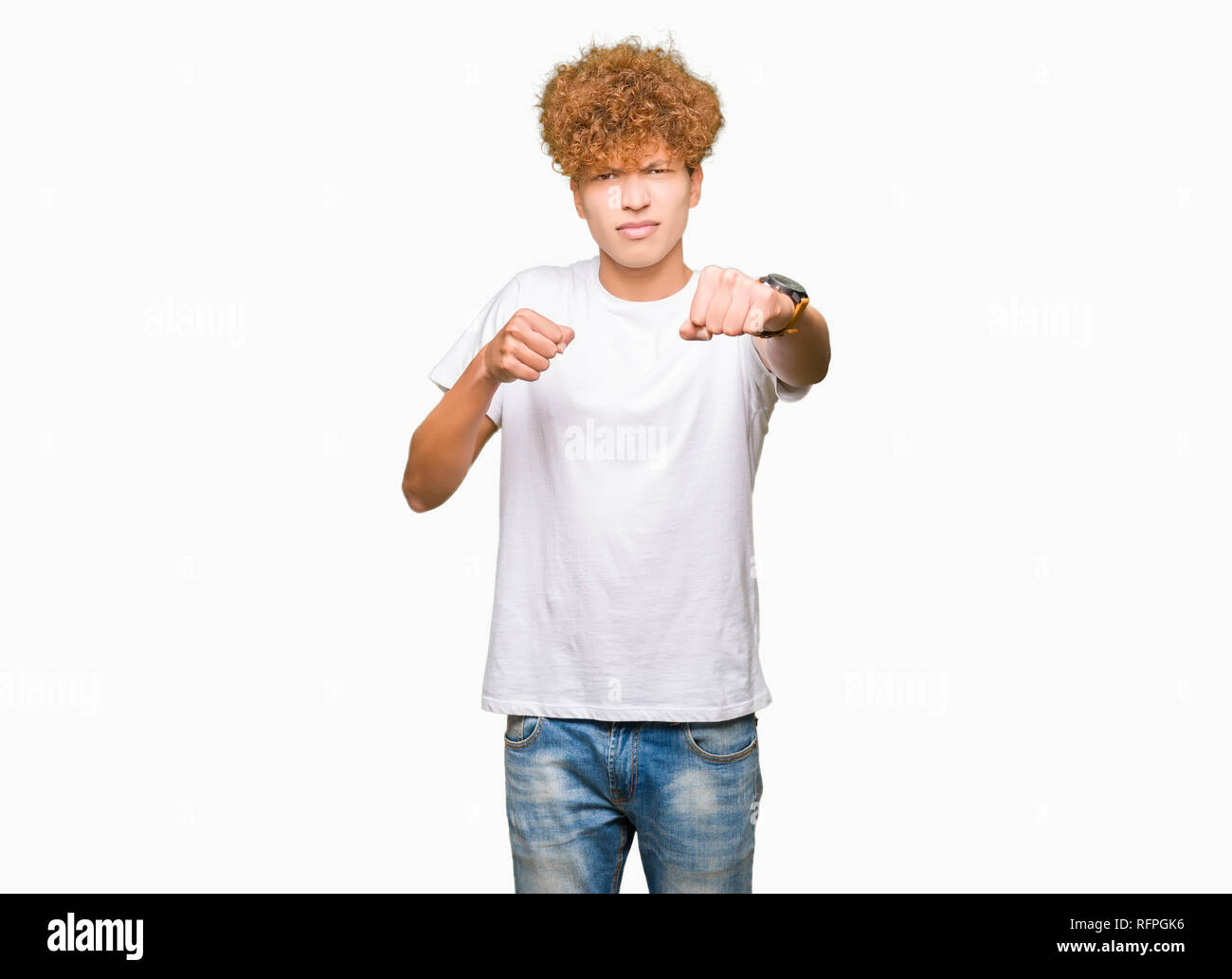 Young handsome man with afro hair wearing casual white t-shirt Punching ...