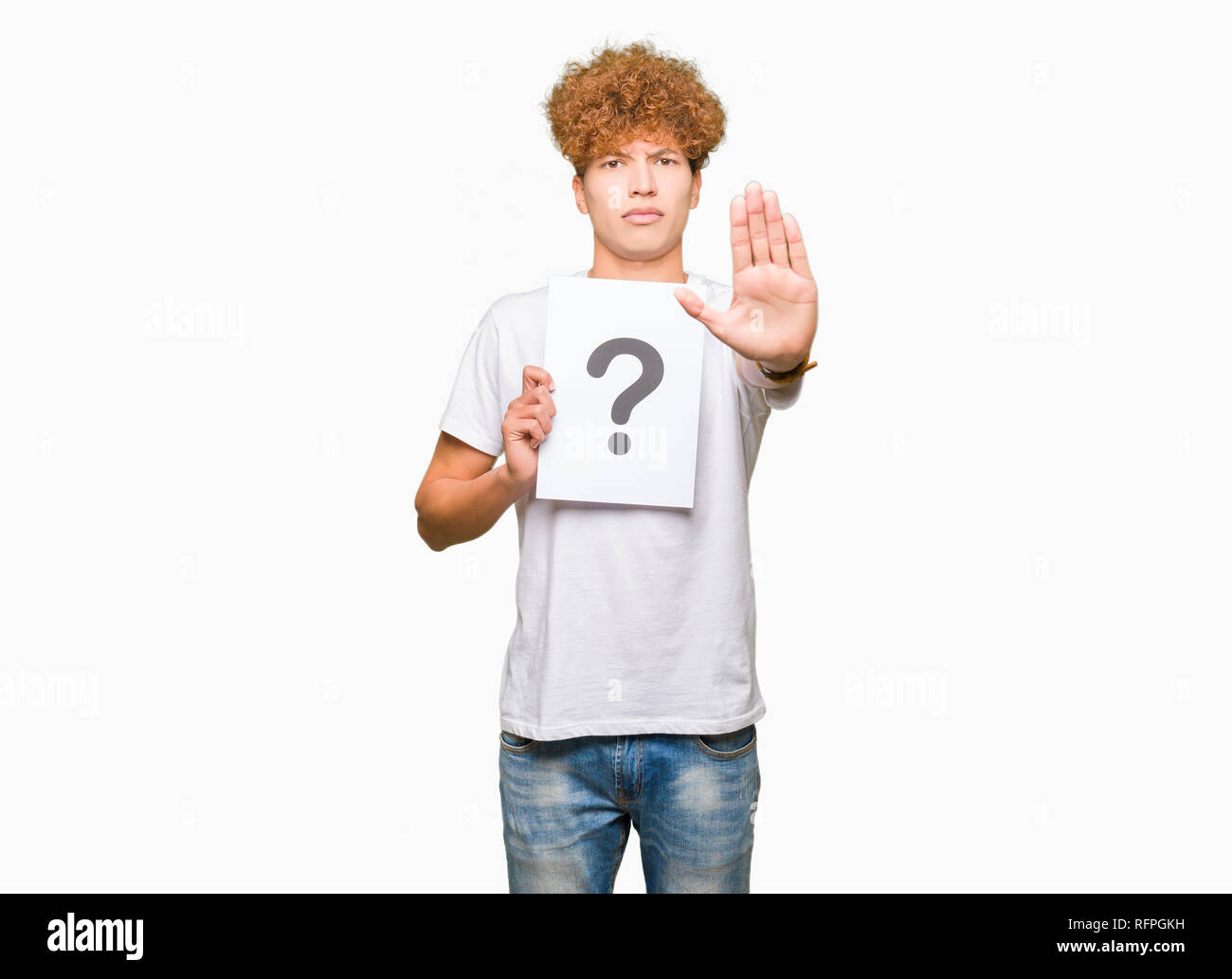 Young handsome man holding paper with question mark with open hand ...