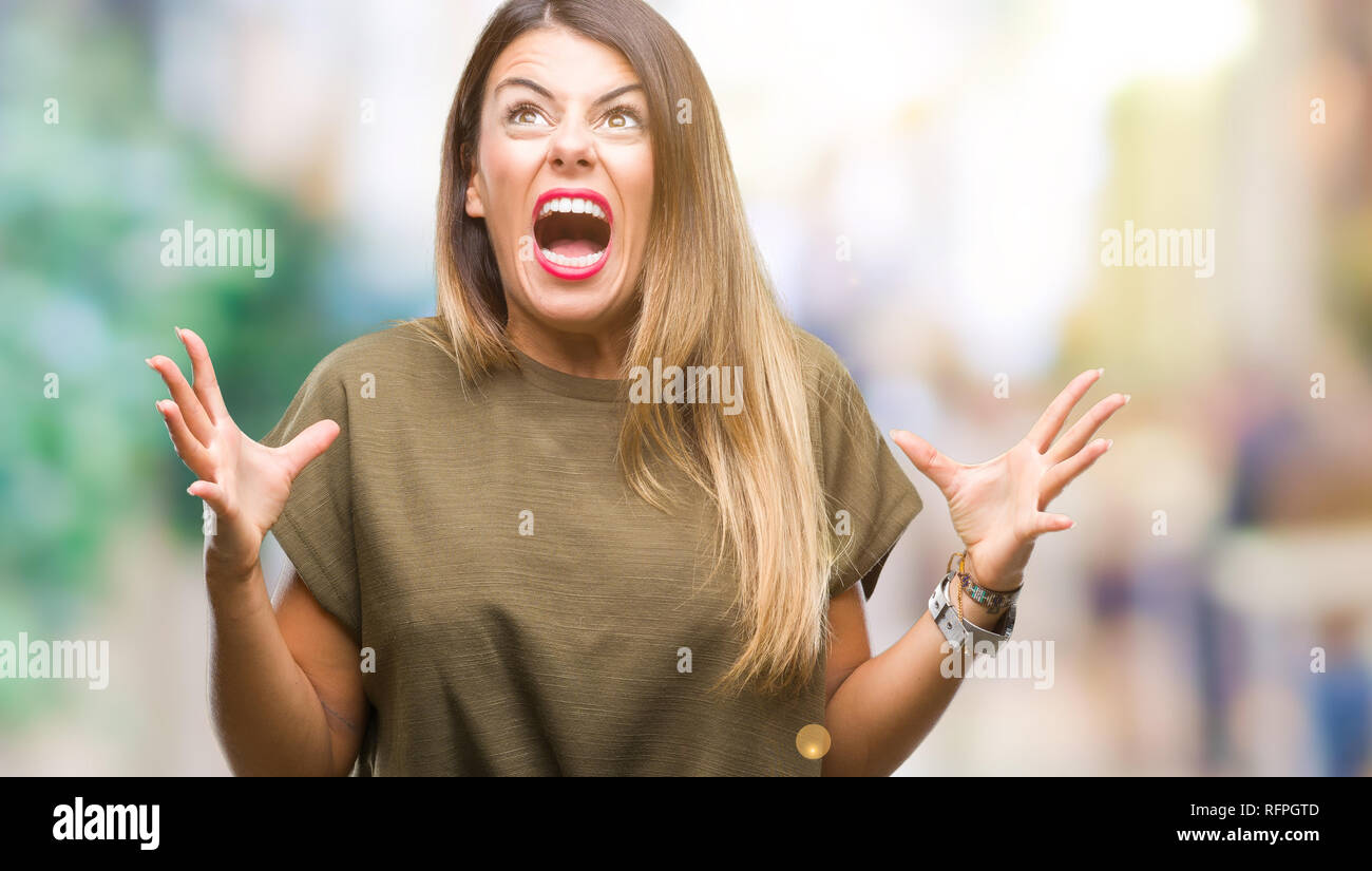 Young beautiful woman over isolated background crazy and mad shouting ...