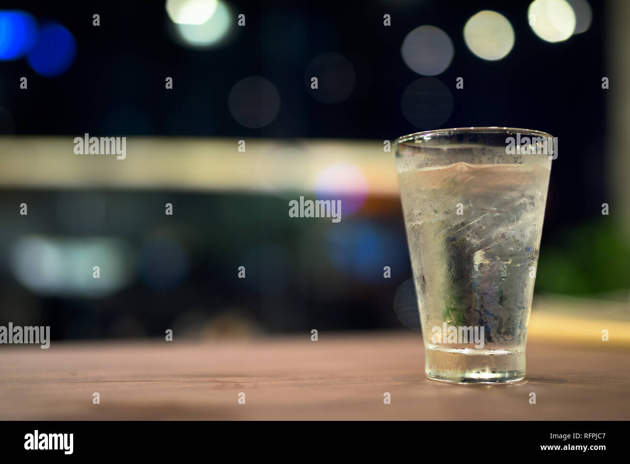 Glass Of Drinking Water Indoors On Table With City Background At Night ...