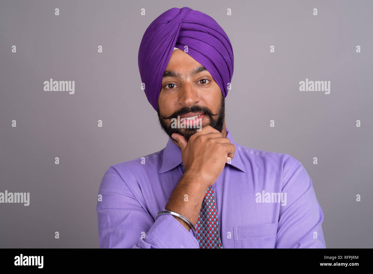 Young handsome Indian Sikh businessman wearing turban against gr Stock ...