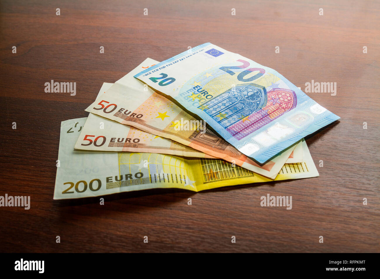 European cash money stack isolated on a dark wood table Stock Photo - Alamy