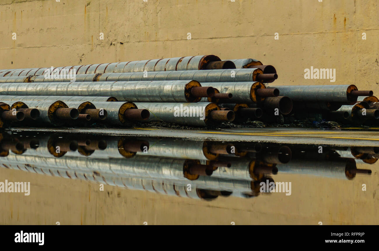 A pile of steel pillars on a construction site with a reflection of it ...