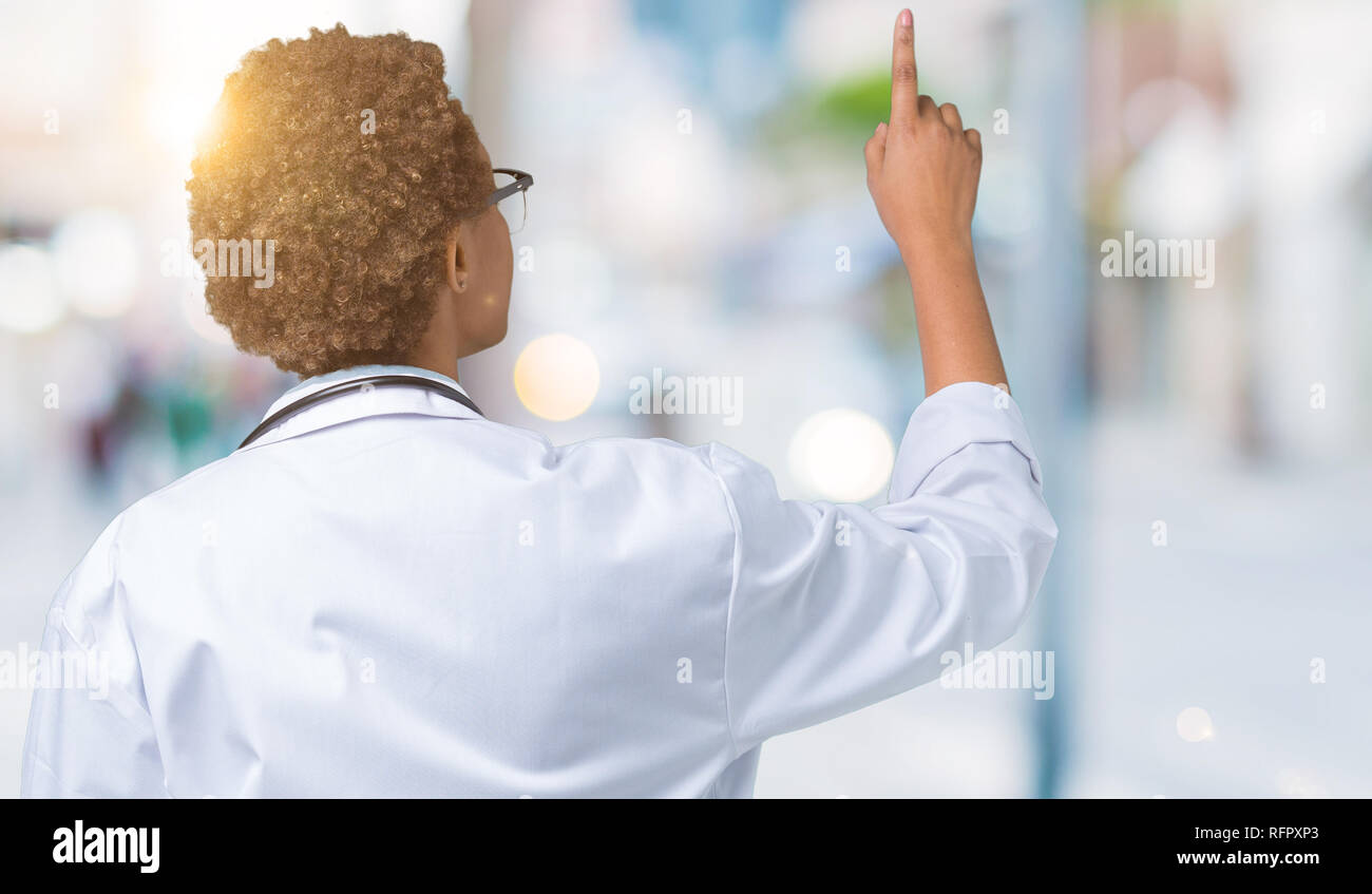 Young african american doctor woman wearing medical coat over isolated ...
