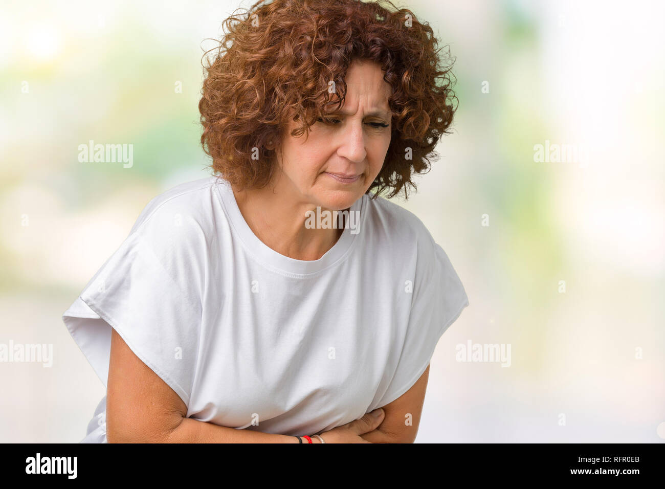 Beautiful middle ager senior woman wearing white t-shirt over isolated ...