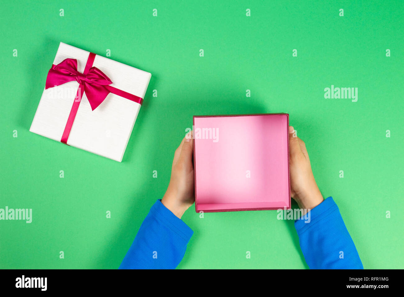 Kid hands hold the blank empty present gift box on pastel green ...