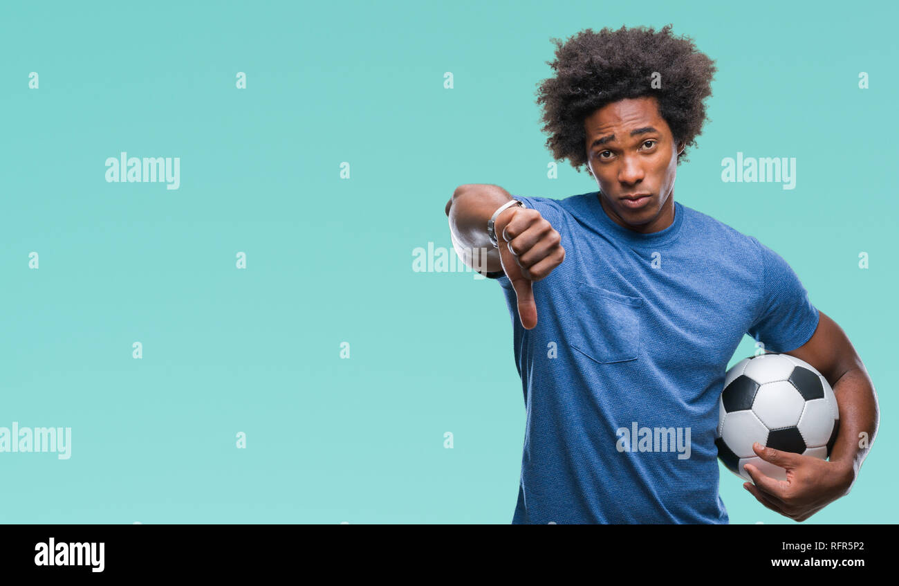 Afro american man holding football ball over isolated background with ...