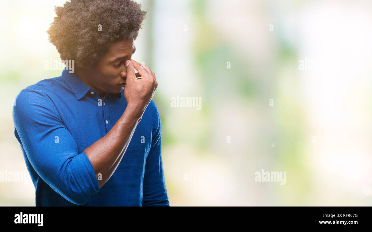 Afro american man over isolated background tired rubbing nose and eyes ...