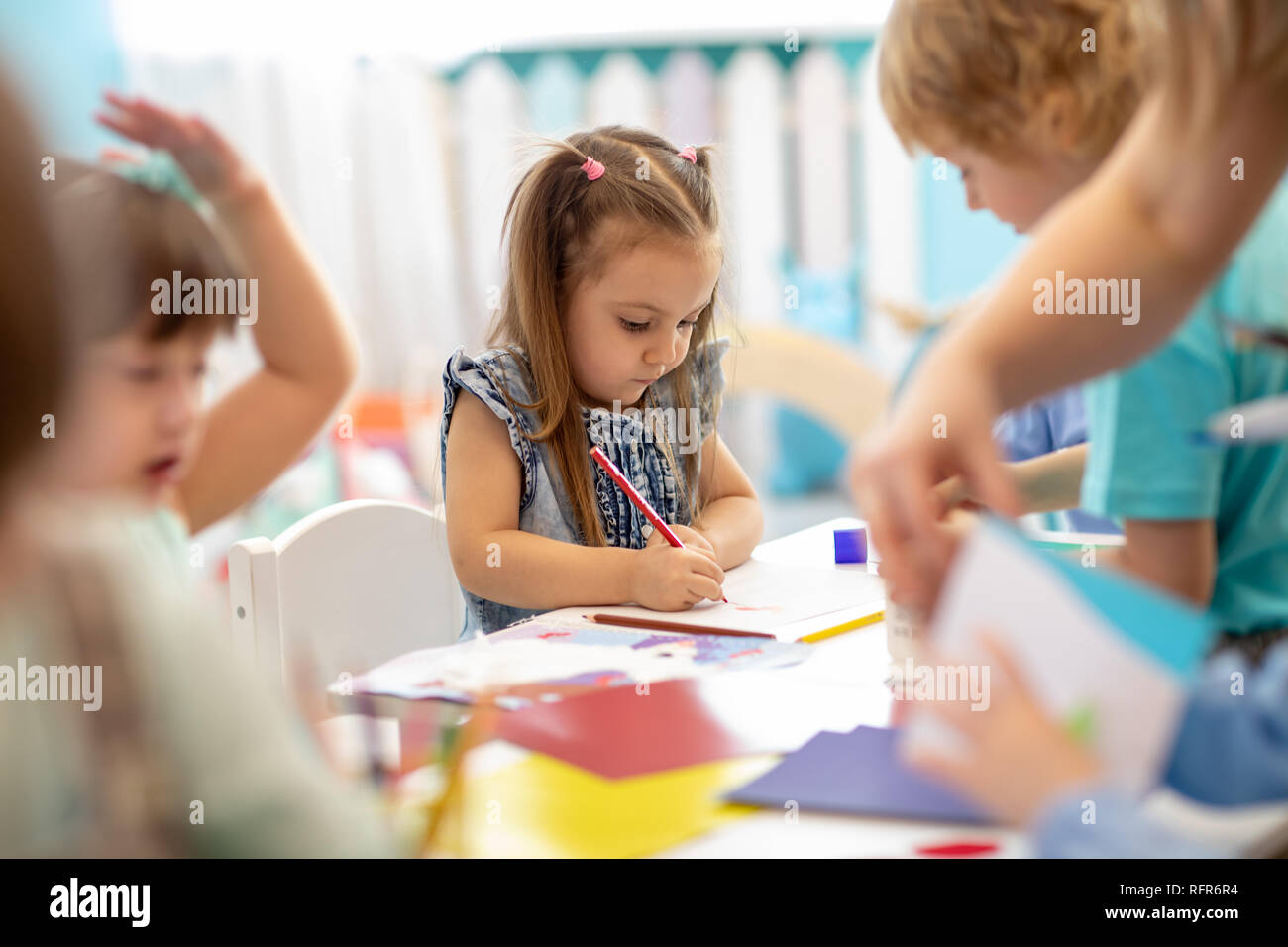 Group of children drawing with nursery teacher in kindergarten Stock ...