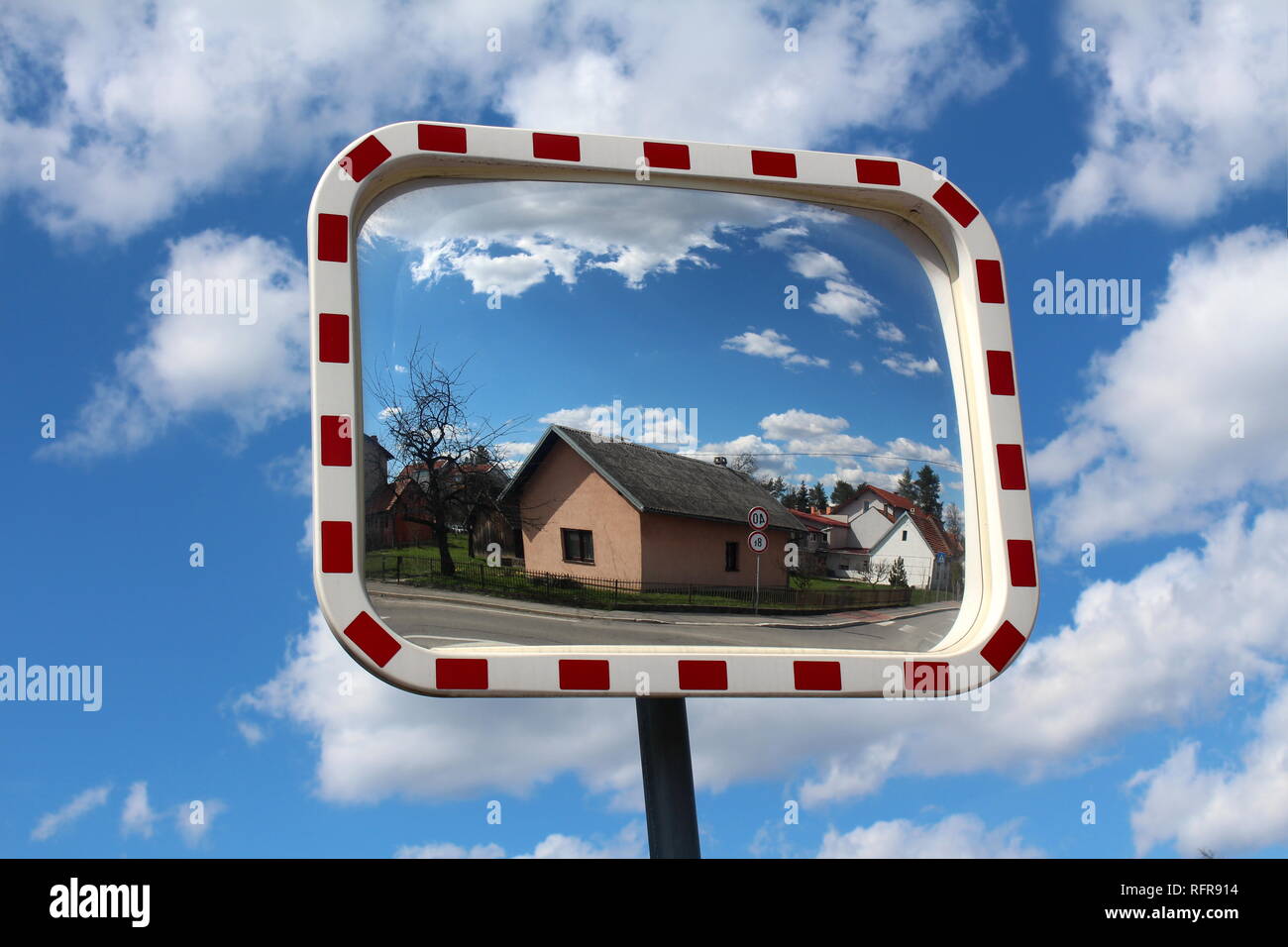 Convex rectangular traffic mirror mounted on metal pole with ...