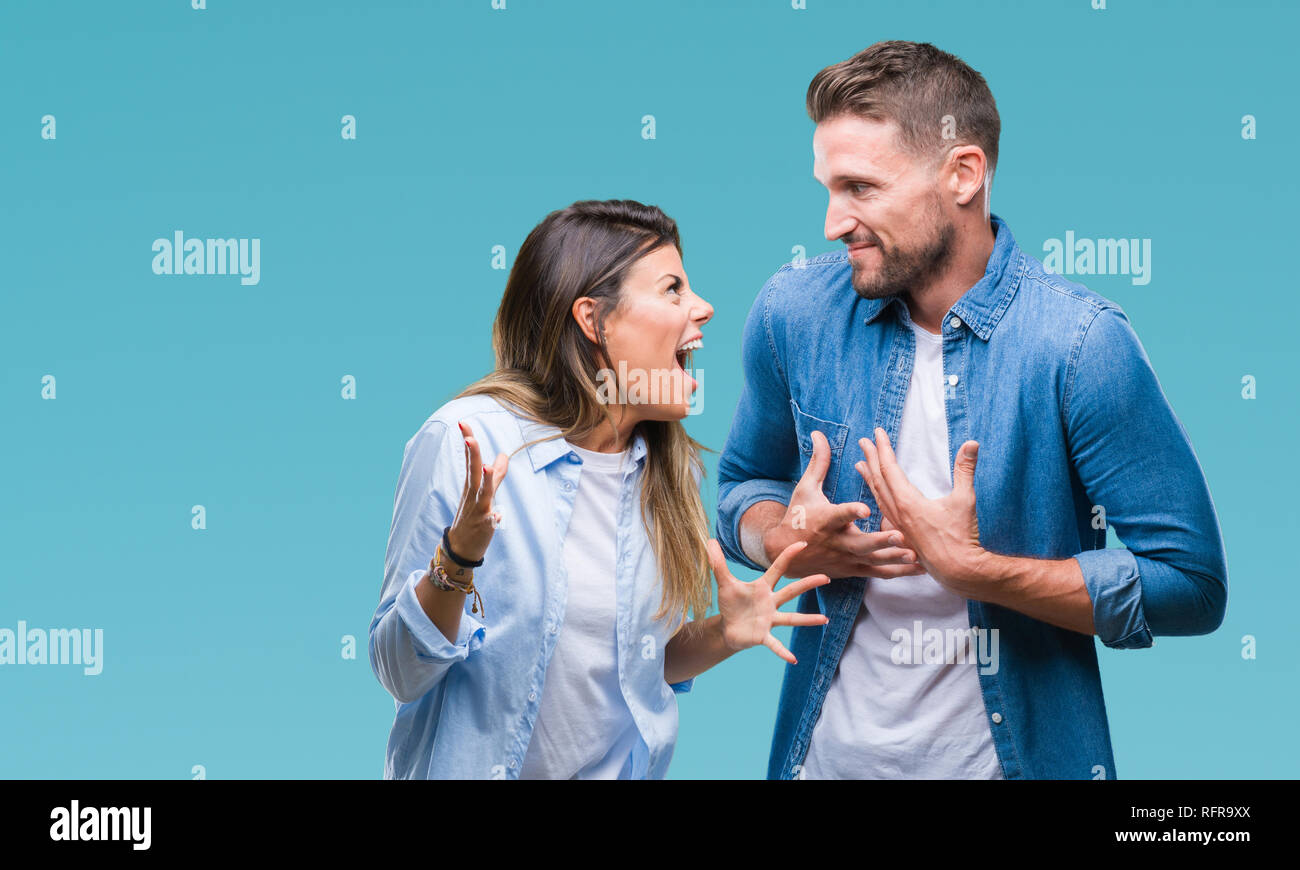 Young couple in love over isolated background crazy and mad shouting ...