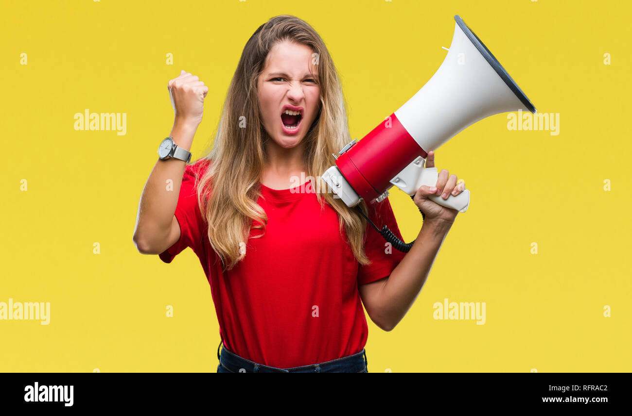Young beautiful blonde woman yelling through megaphone over isolated ...