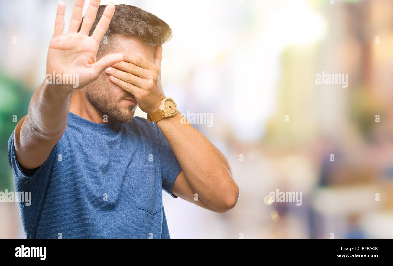 Young handsome man over isolated background covering eyes with hands ...
