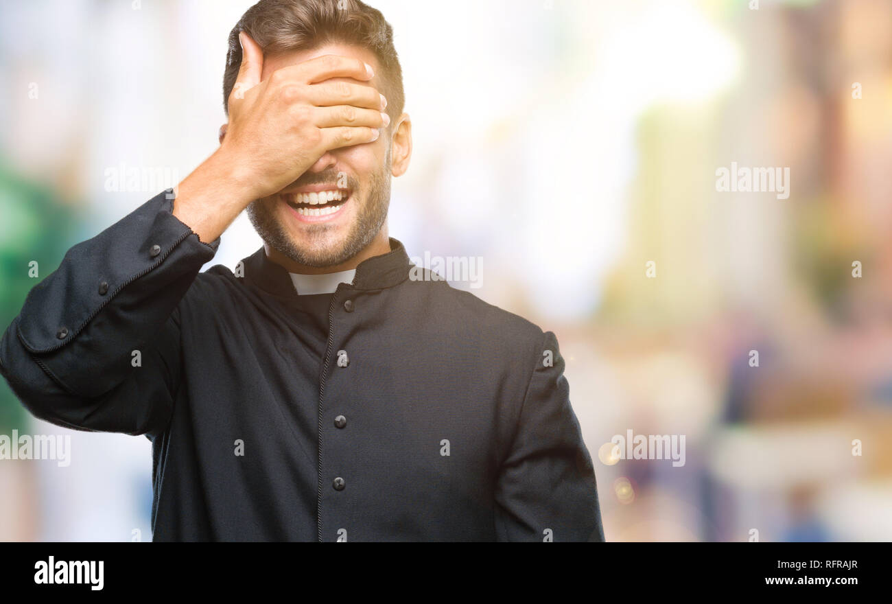 Young catholic christian priest man over isolated background smiling ...