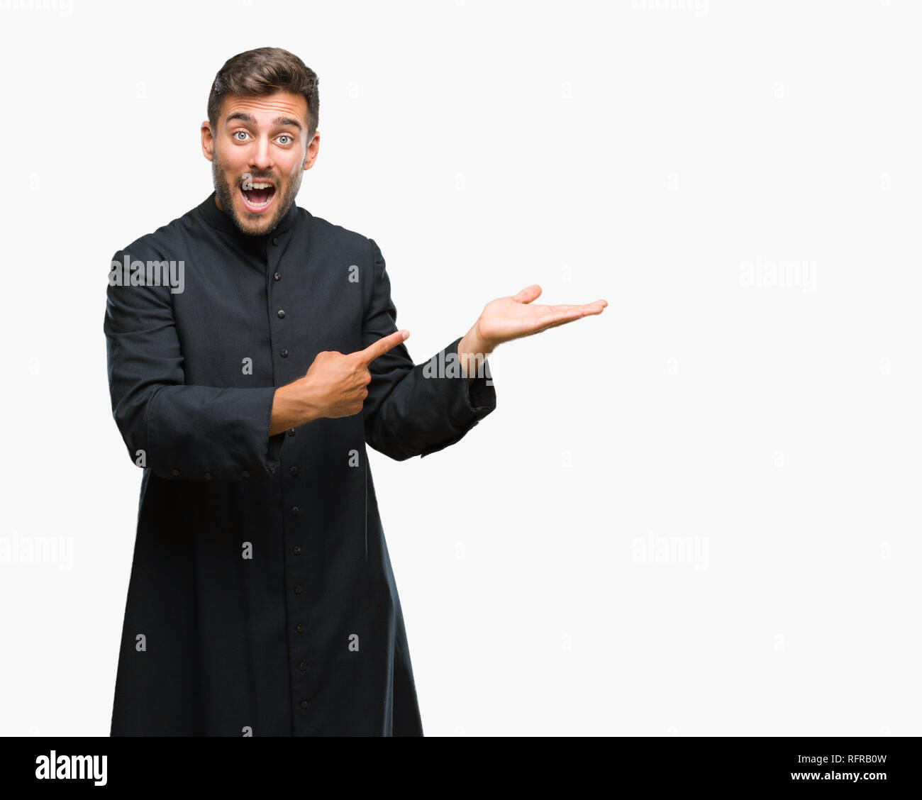 Young catholic christian priest man over isolated background amazed and ...