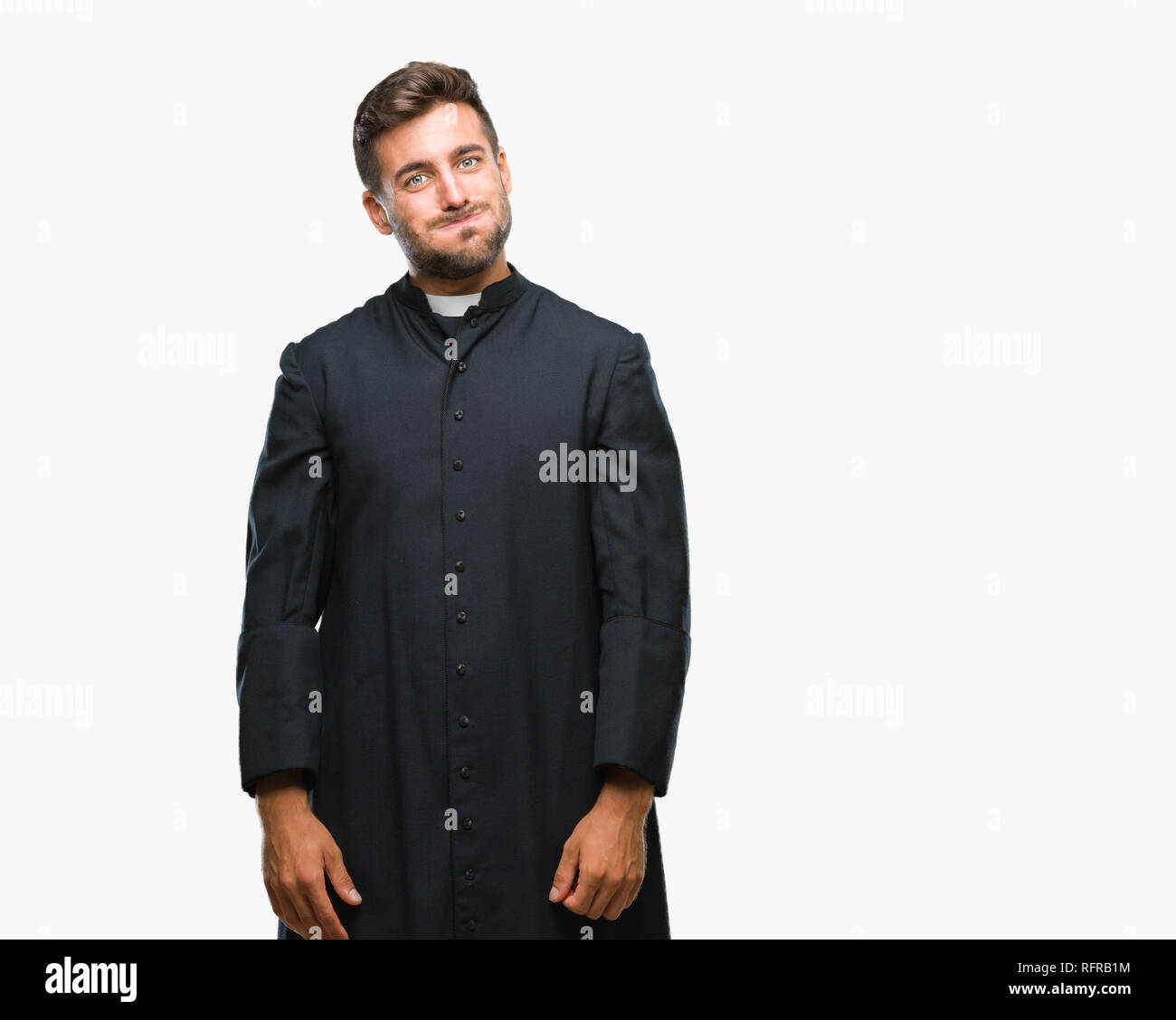 Young catholic christian priest man over isolated background puffing ...