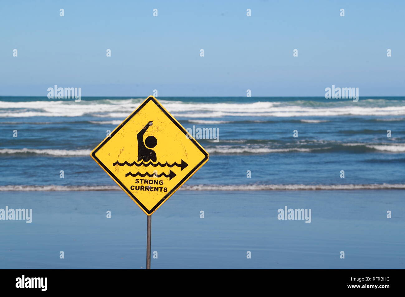 Warning sign "Strong currents" at Piha beach, New Zealand Stock Photo ...