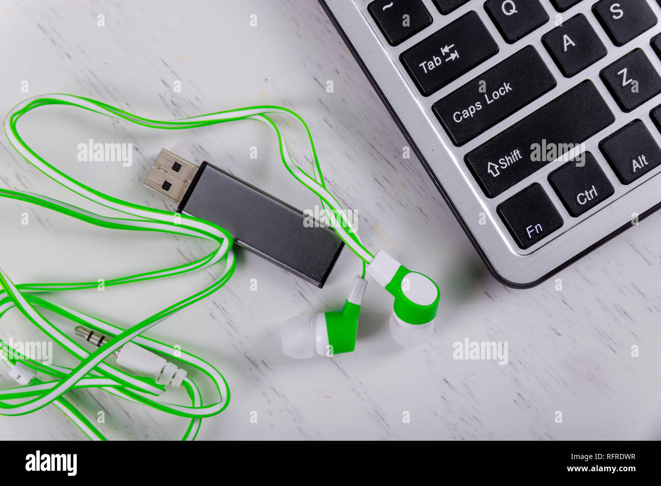 Computer laptop with USB flash drives, headphones and gadgets for a ...