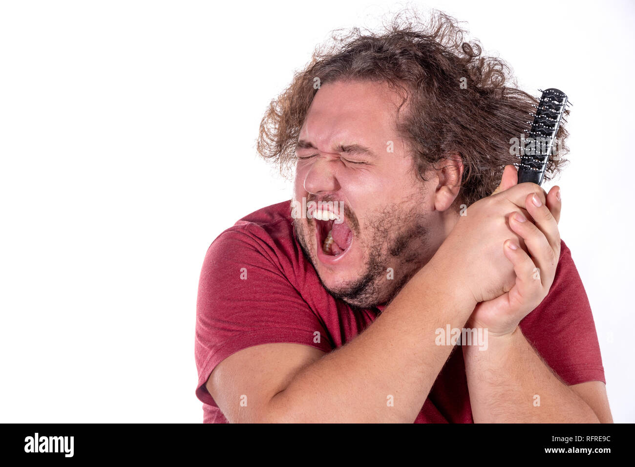Close up portrait of fat man tries to comb his tangled and naughty hair ...