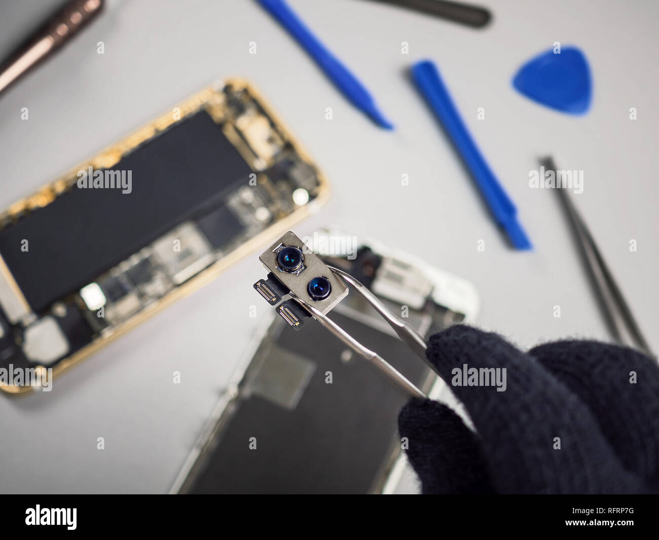 Technician or engineer showing broken dual smartphone camera on blurred ...