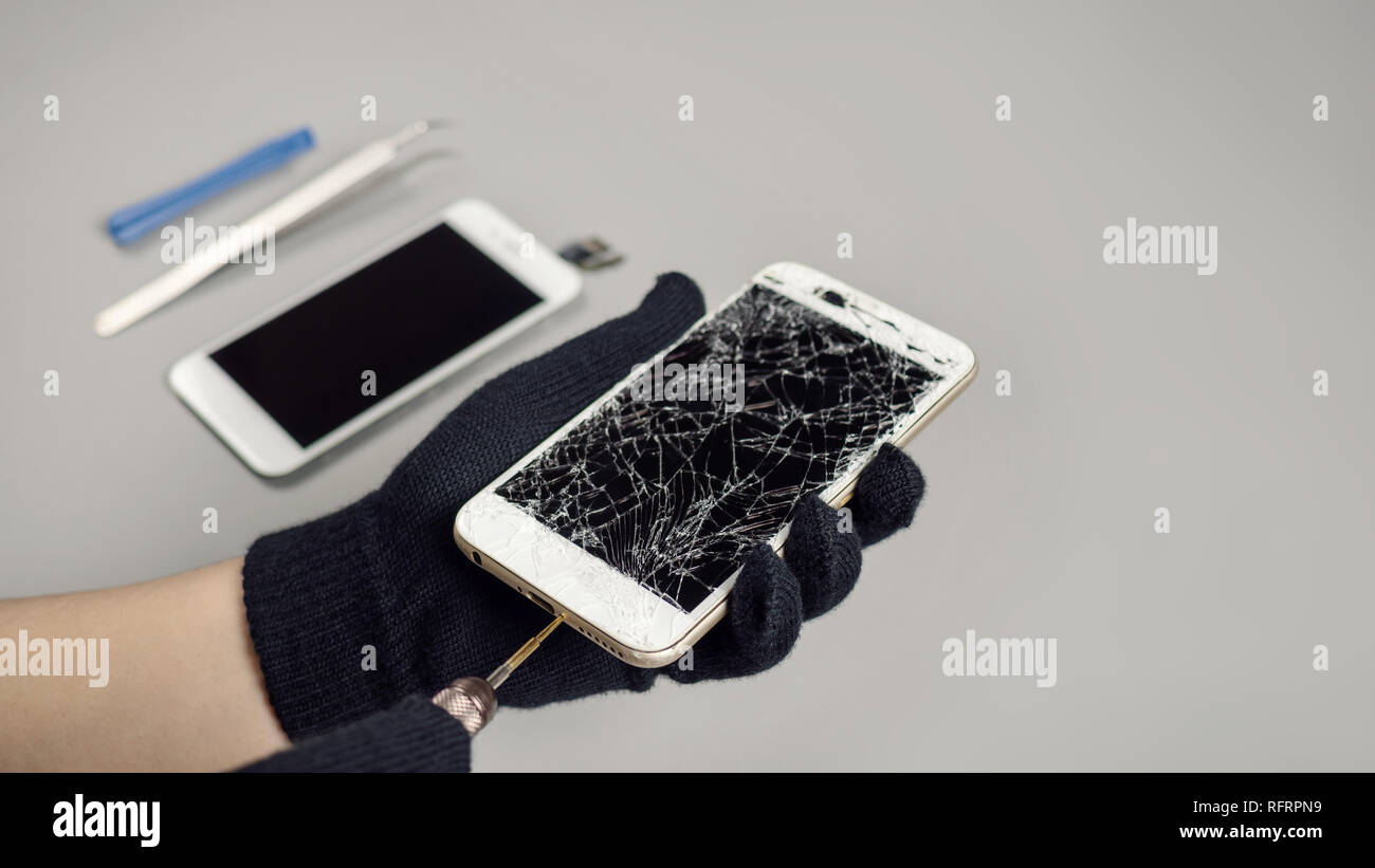 Technician or engineer opening broken smartphone for repair or replace ...