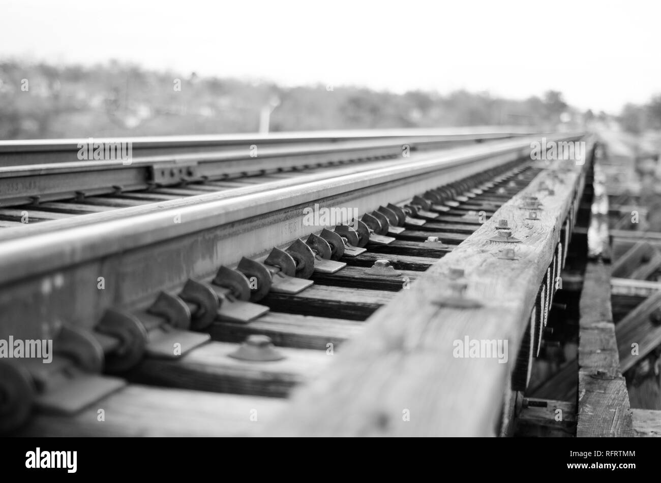 Black and white railroad tracks running into distance Stock Photo - Alamy