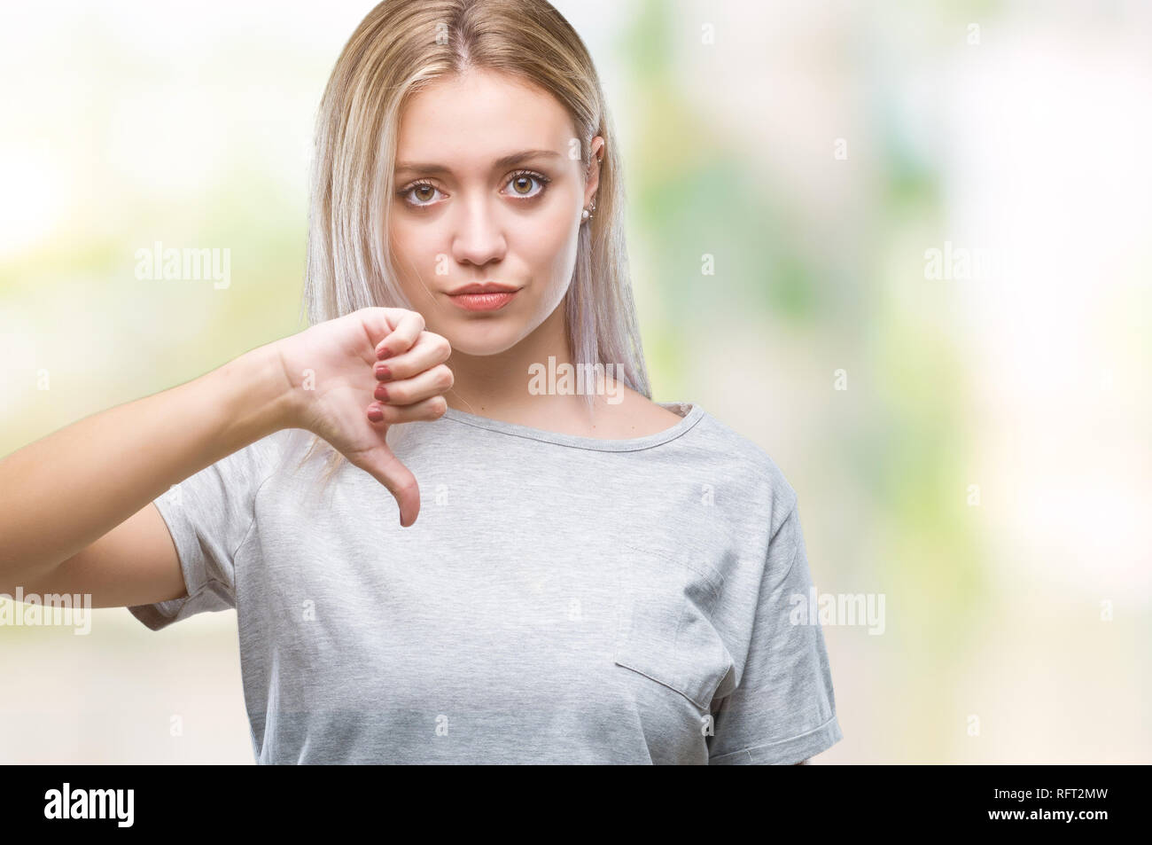 Young blonde woman over isolated background looking unhappy and angry ...