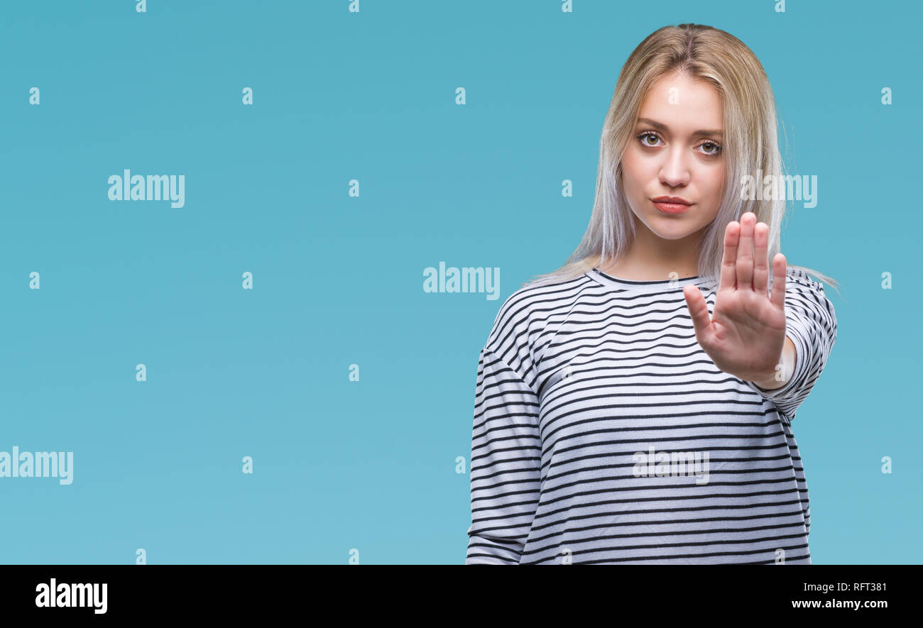 Young blonde woman over isolated background doing stop sing with palm ...