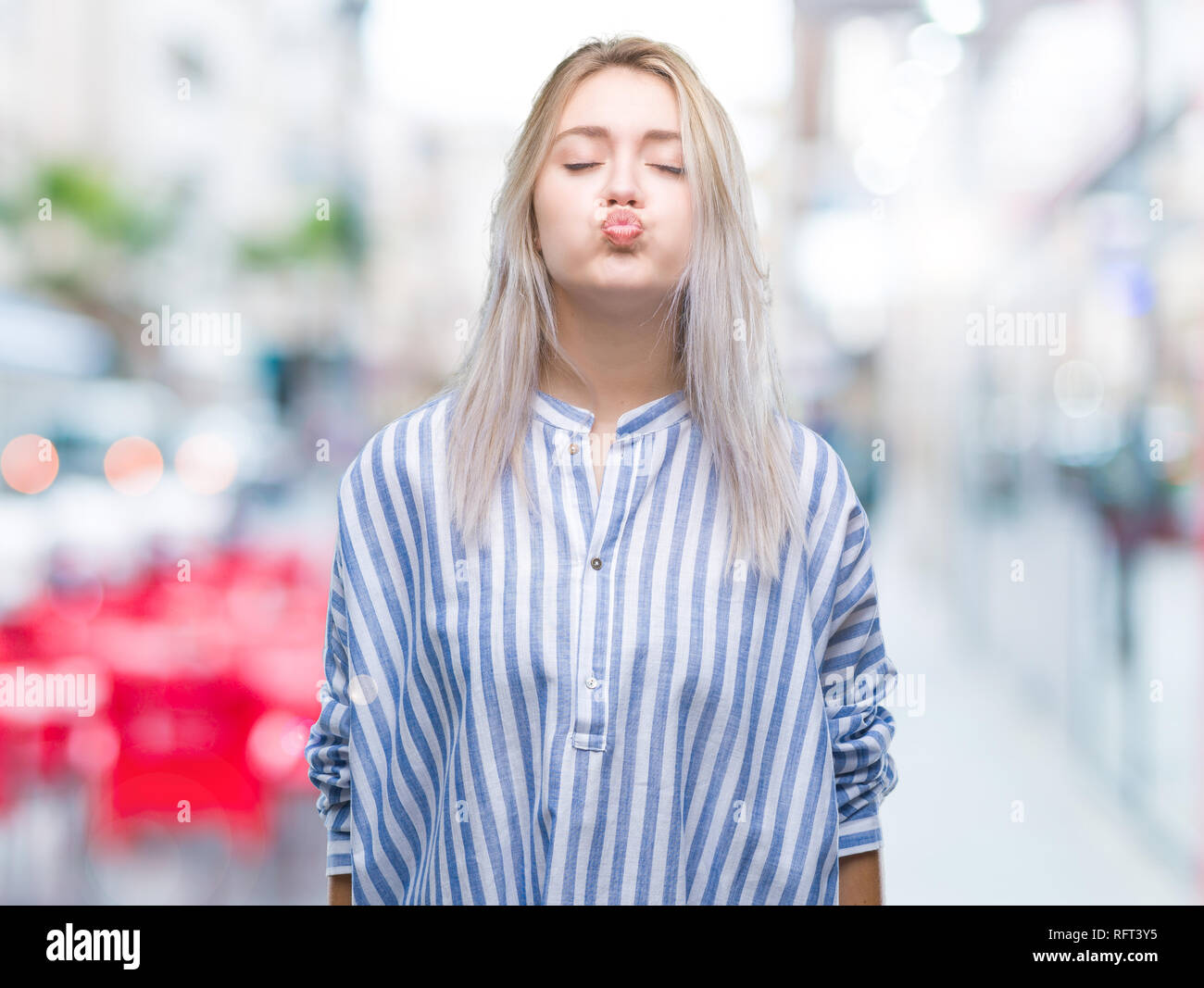 Young blonde woman over isolated background puffing cheeks with funny ...