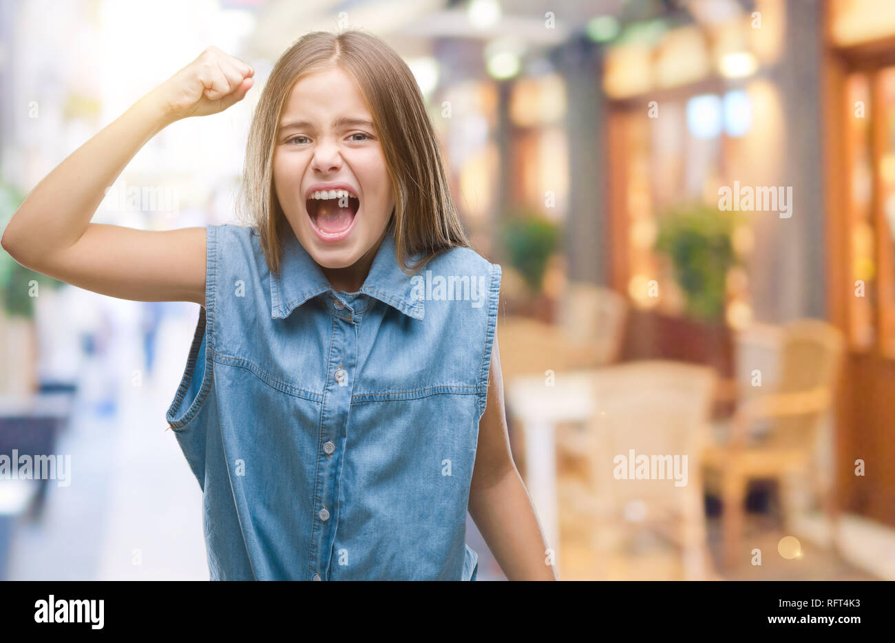 Young beautiful girl over isolated background angry and mad raising ...