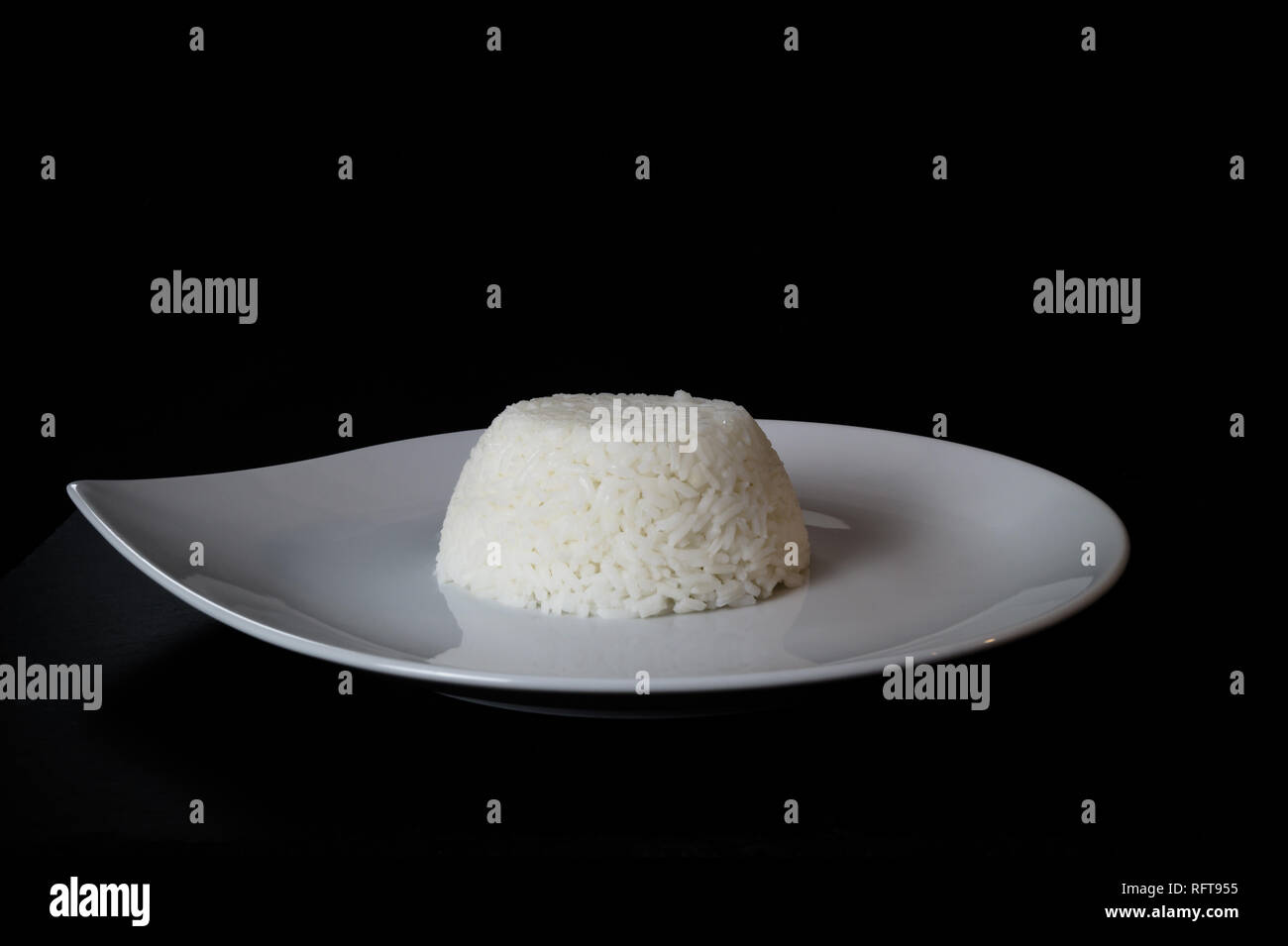 Beautiful image of chinese rice on a white plate and black background ...