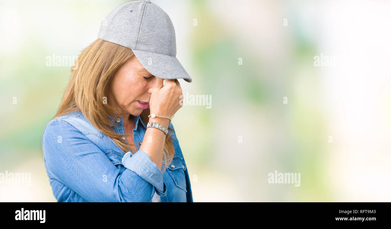 Beautiful middle age woman wearing sport cap over isolated background ...