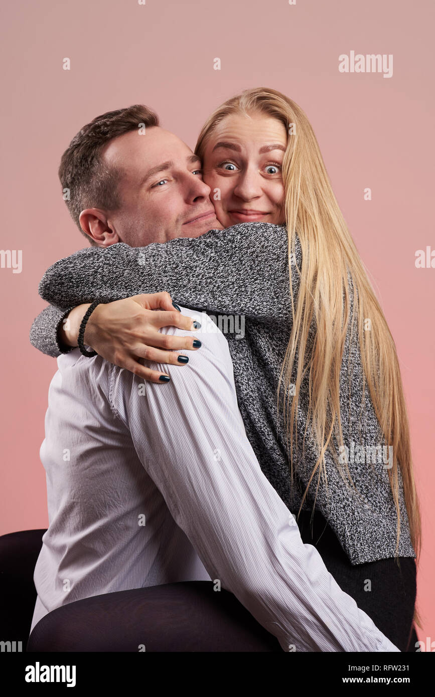 Funny couple making big hug isolated on pink background Stock Photo - Alamy