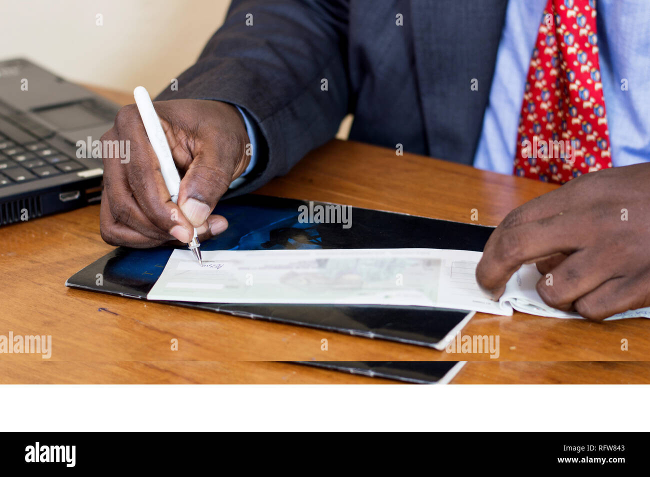 Signing a check in his office Stock Photo - Alamy