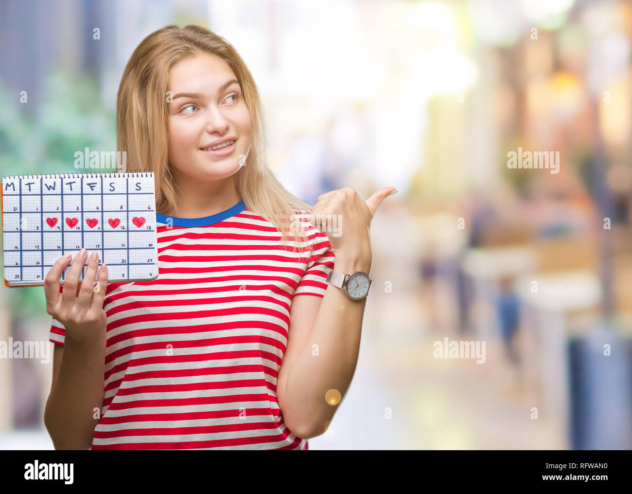 Young caucasian woman holding menstruation calendar over isolated ...