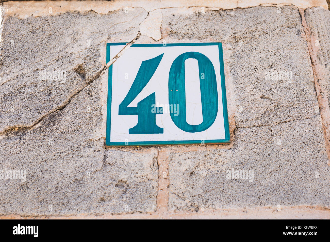 Blue white vintage house number forty 40 on a old aged wall Stock Photo ...