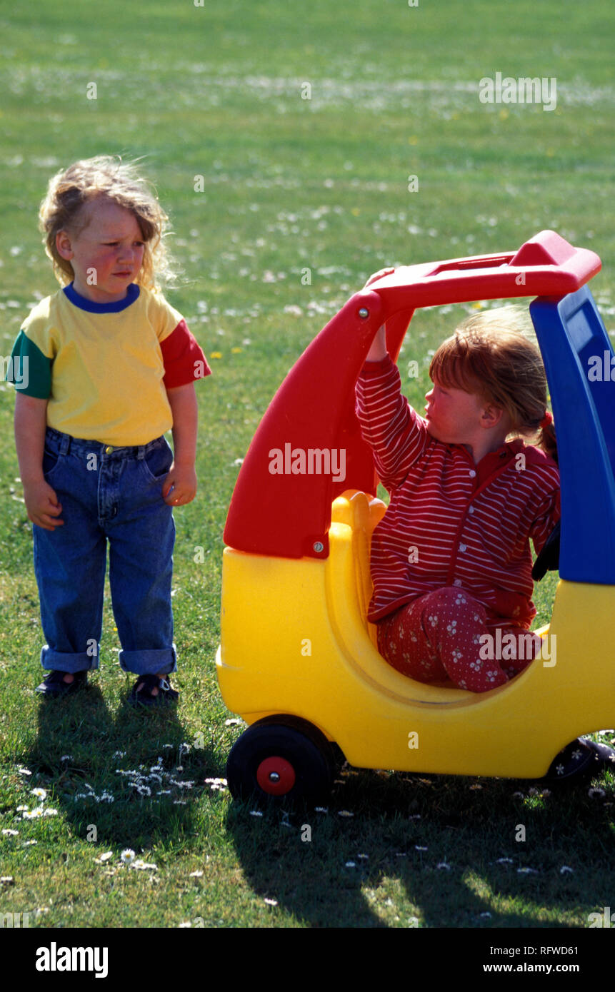 two little children fighting over ride-on car Stock Photo - Alamy