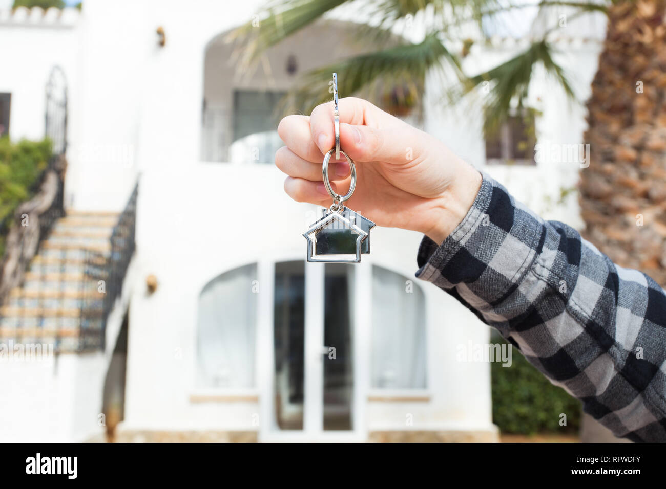 Real estate and property concept - Hand is holding house keys on house ...