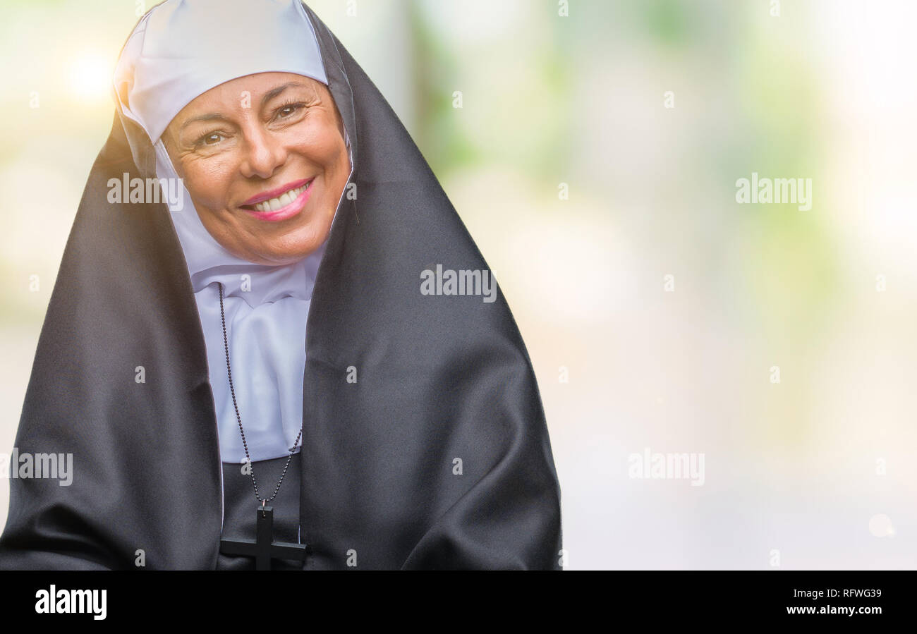 Middle age senior christian catholic nun woman over isolated background ...