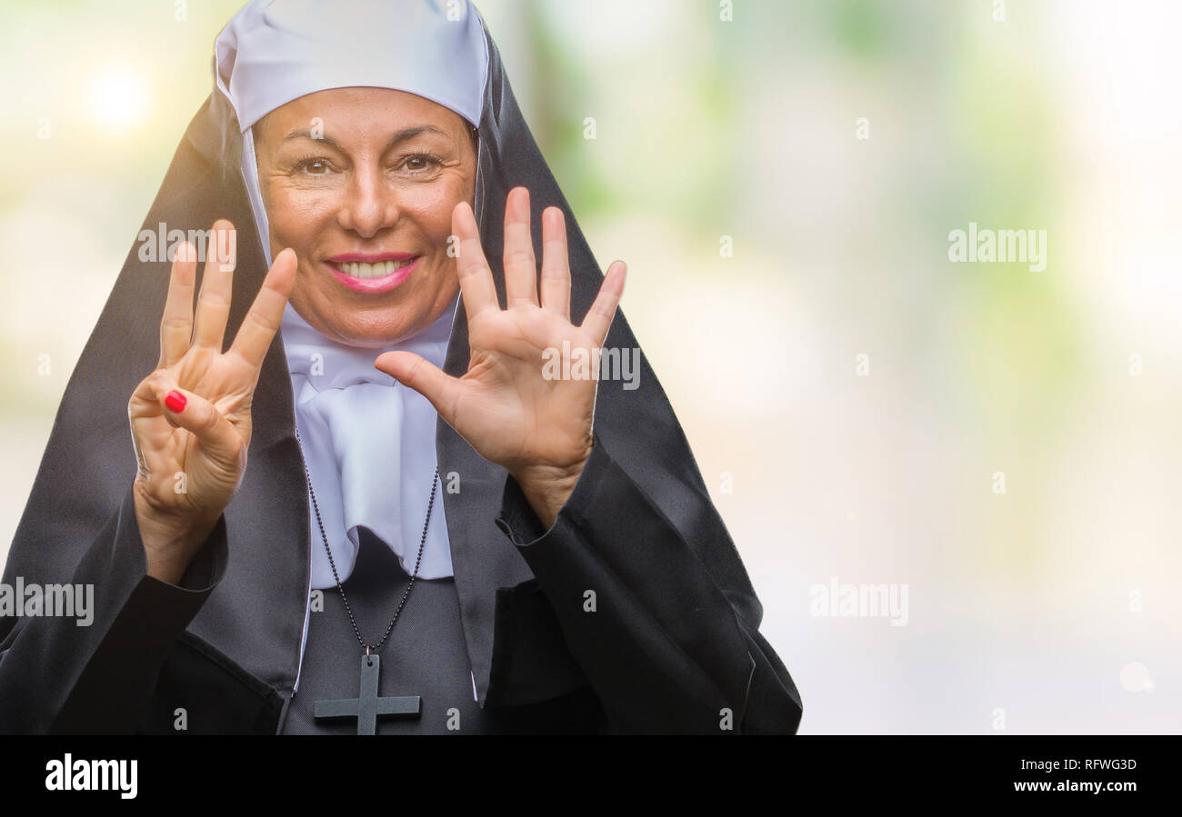 Middle age senior christian catholic nun woman over isolated background ...