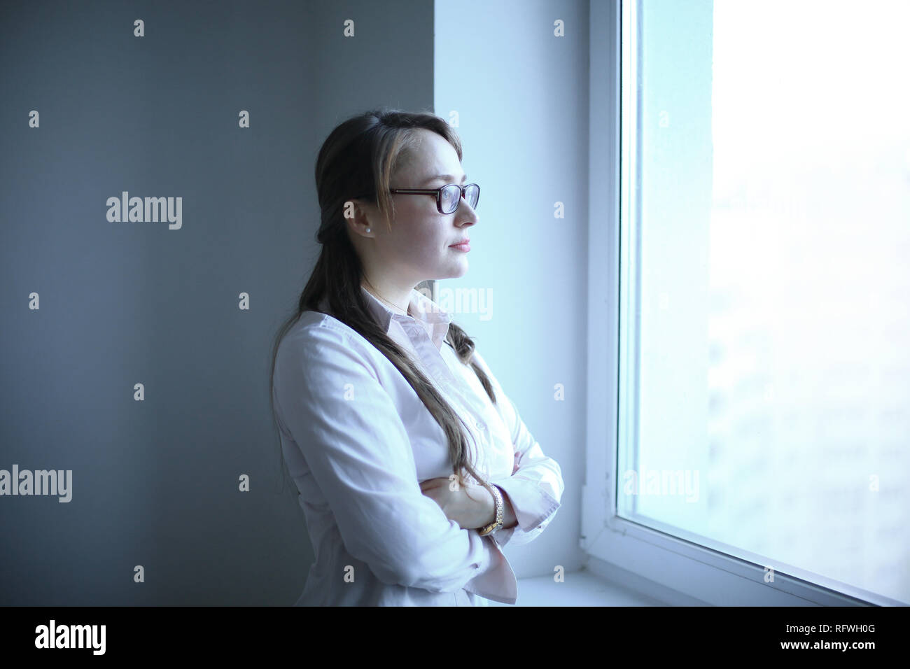 Executive business woman looking out the office window Stock Photo - Alamy