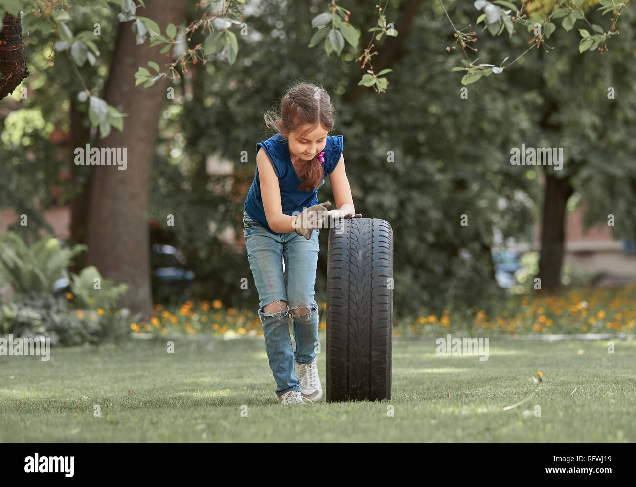 little girl playing with a car tire on the Playground Stock Photo - Alamy
