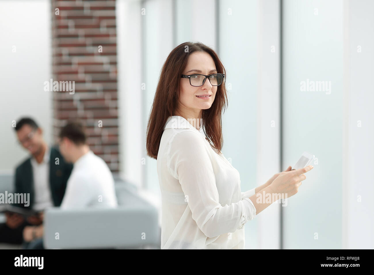 Executive businesswoman standing near a large office window Stock Photo ...