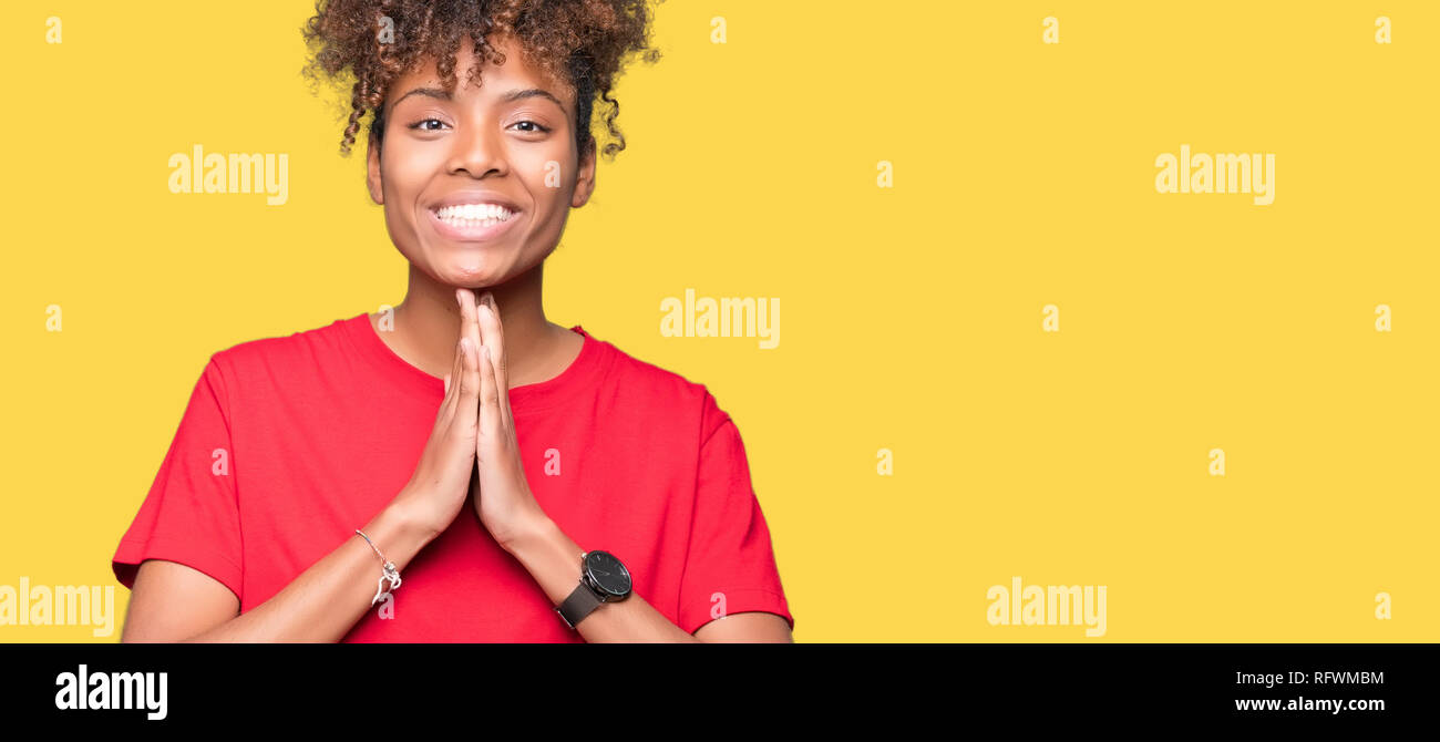 Beautiful young african american woman over isolated background praying ...