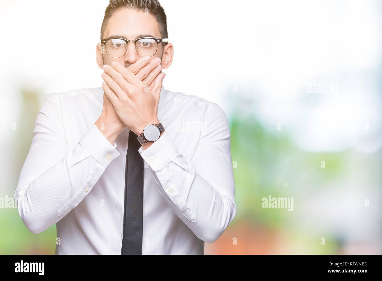 Young handsome business man wearing glasses over isolated background shocked covering mouth with ...