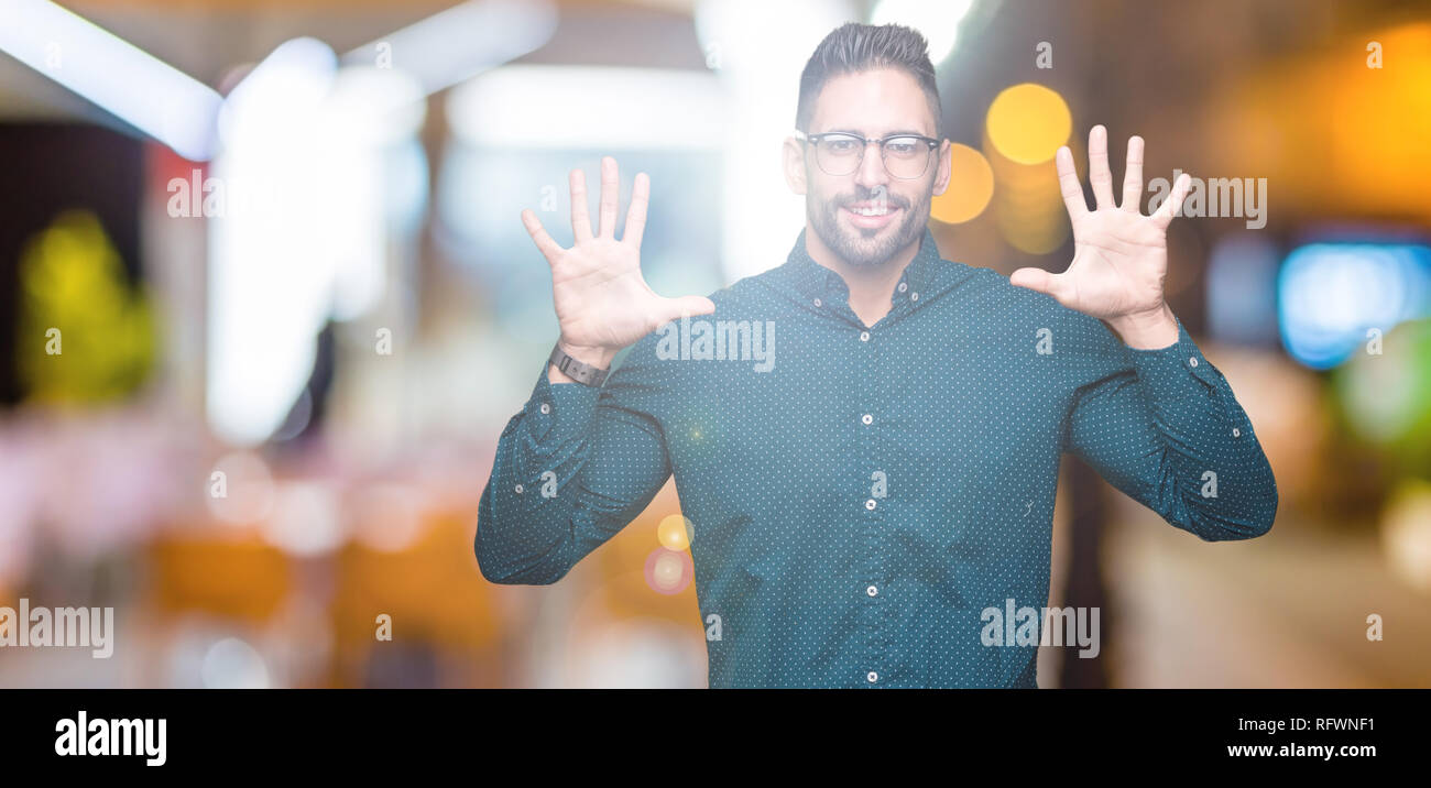 Young handsome business man wearing glasses over isolated background ...