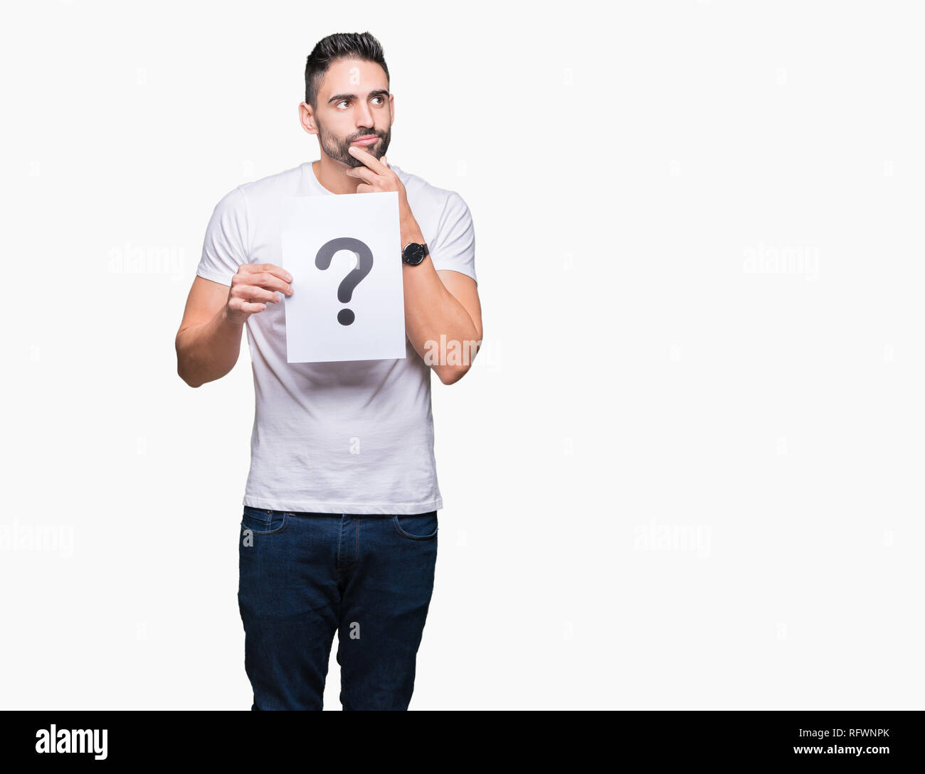 Handsome young man holding paper with question mark over isolated ...