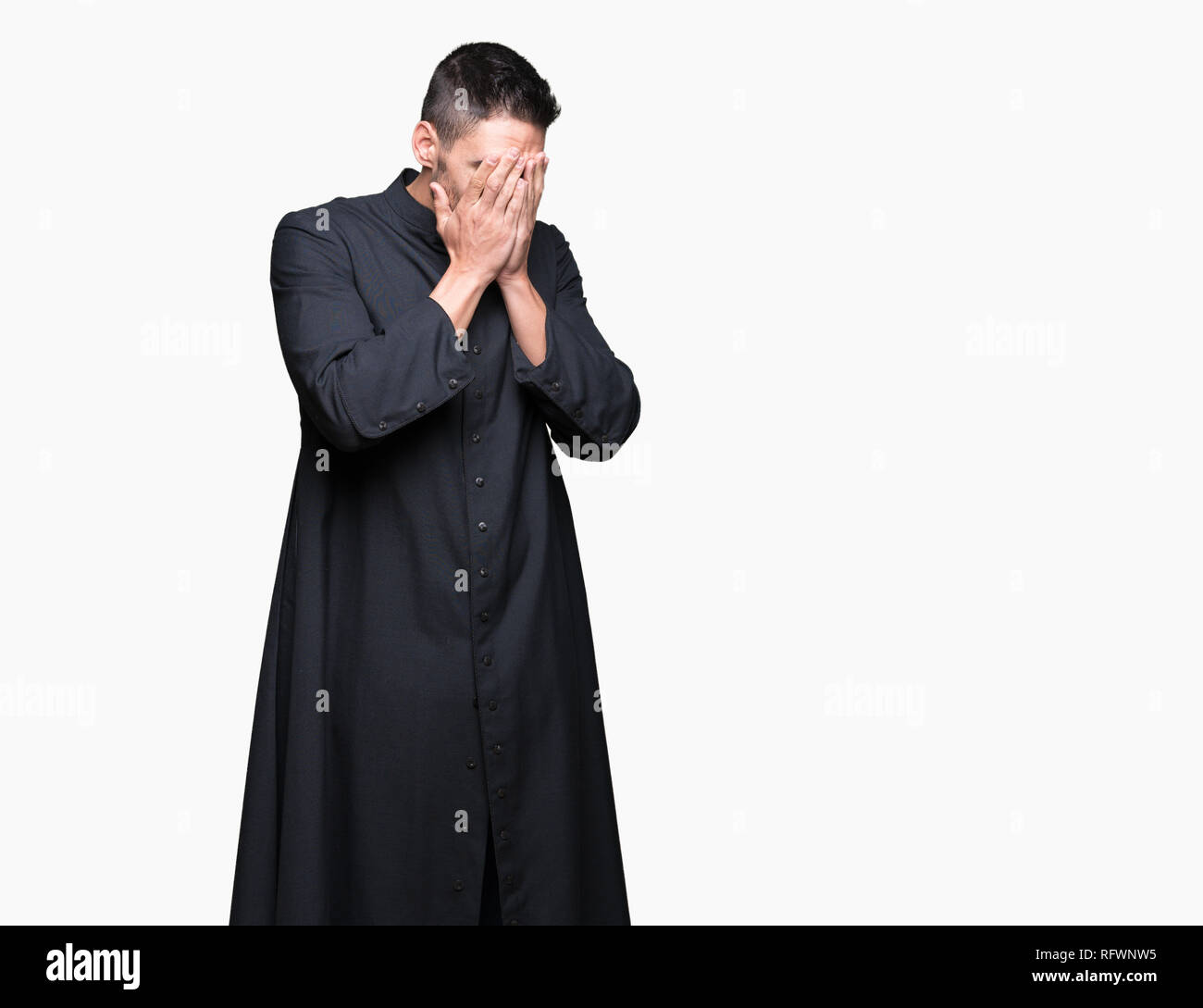 Young Christian priest over isolated background with sad expression ...