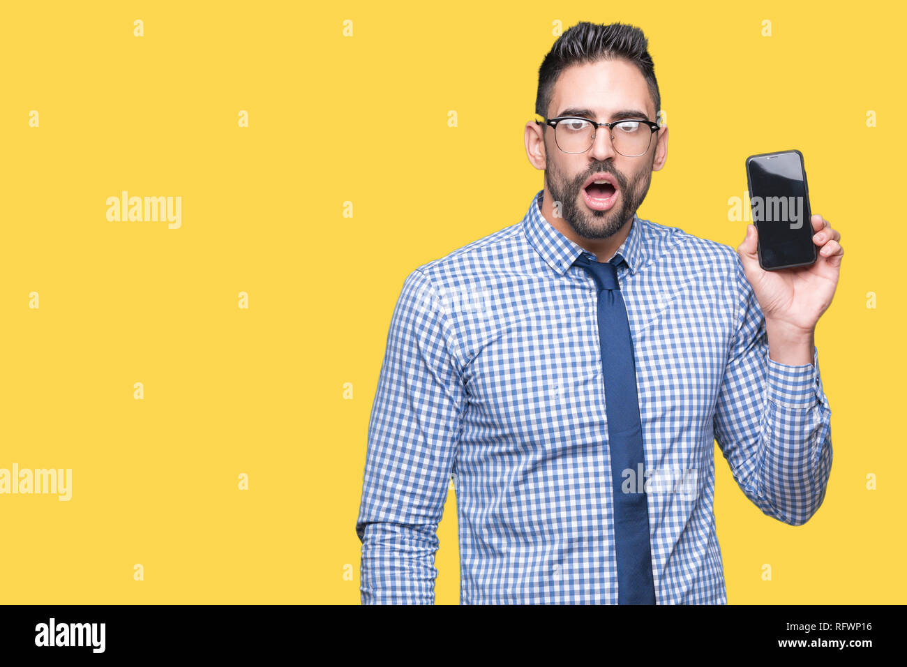 Young business man showing smartphone screen over isolated background ...